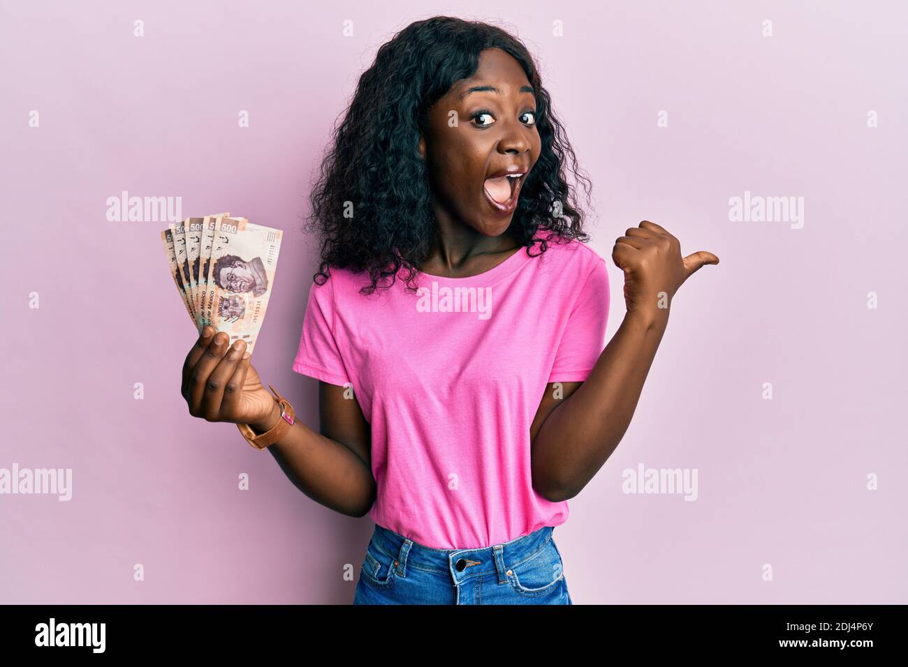 Beautiful african young woman holding 500 mexican pesos banknotes ...