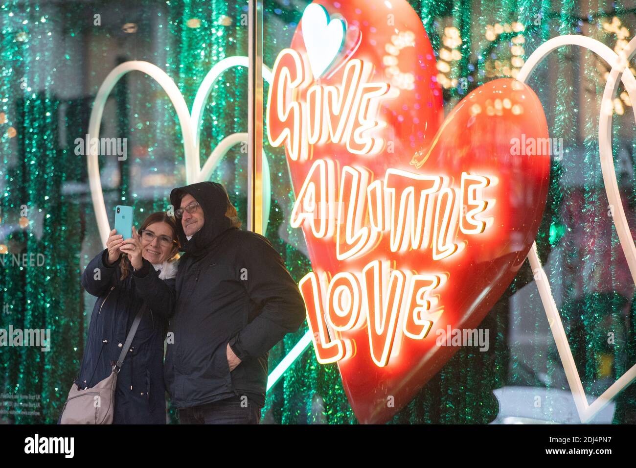 Shoppers take a selfie outside a window display on Oxford Street, in ...