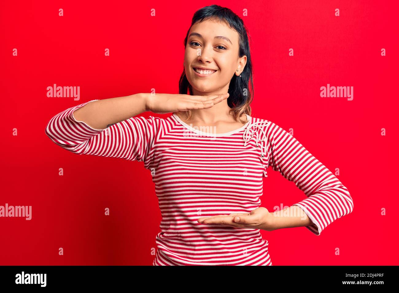 Young woman wearing casual clothes gesturing with hands showing big and ...