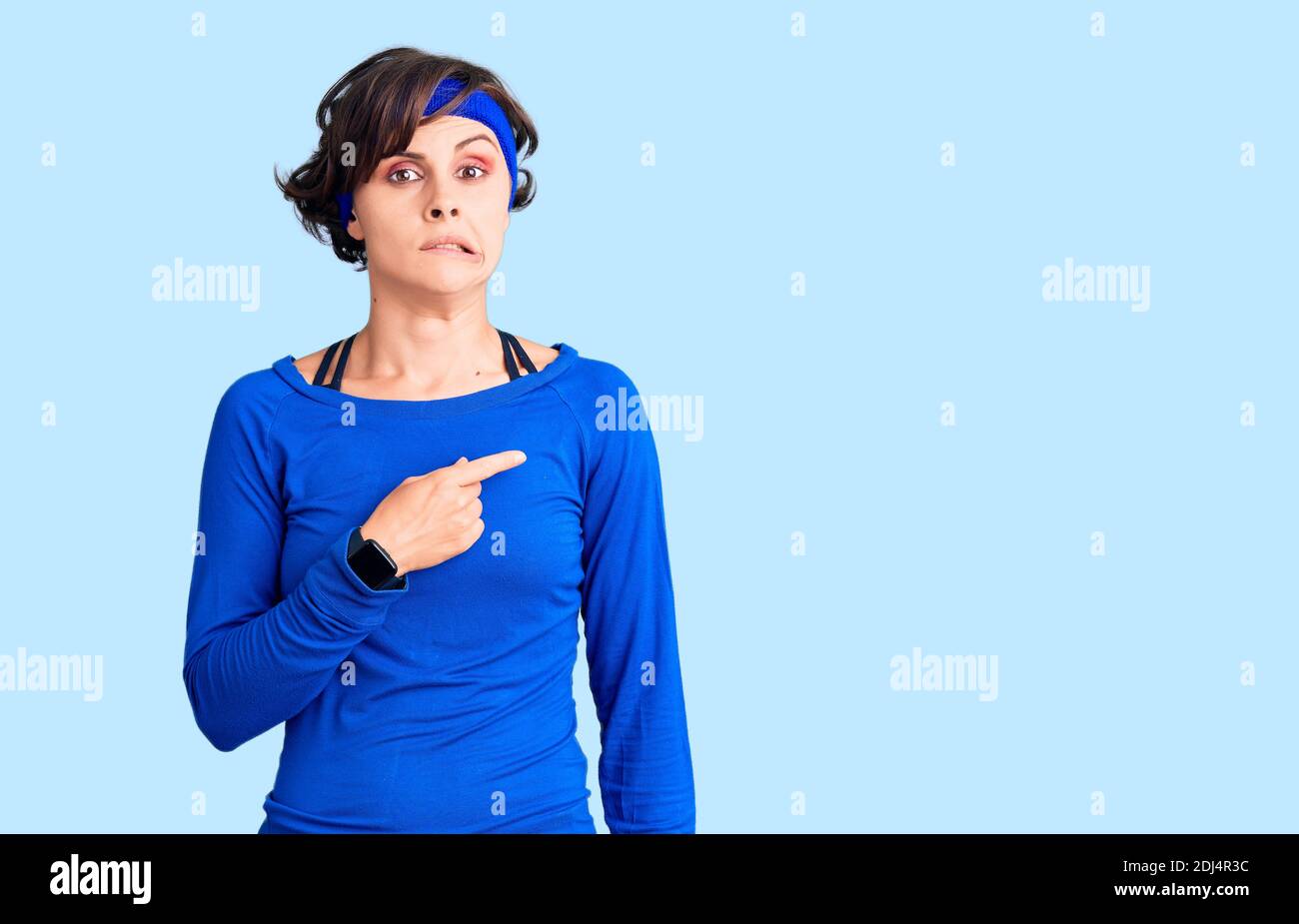 Beautiful young woman with short hair wearing training workout clothes ...