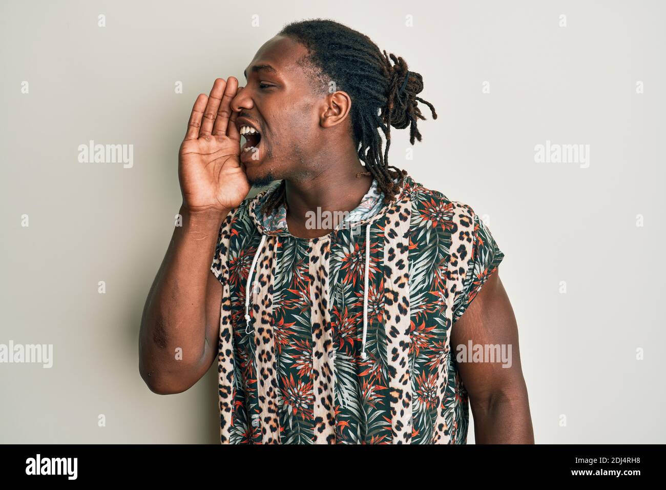 African american man with braids wearing fashion modern shirt shouting ...