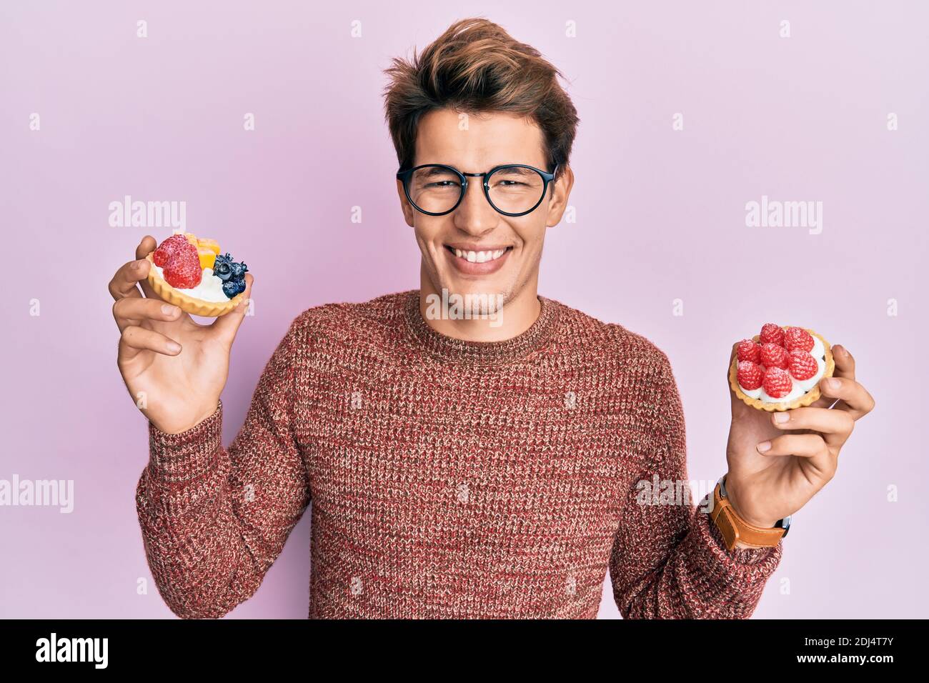 Handsome caucasian man holding cake slices smiling with a happy and ...