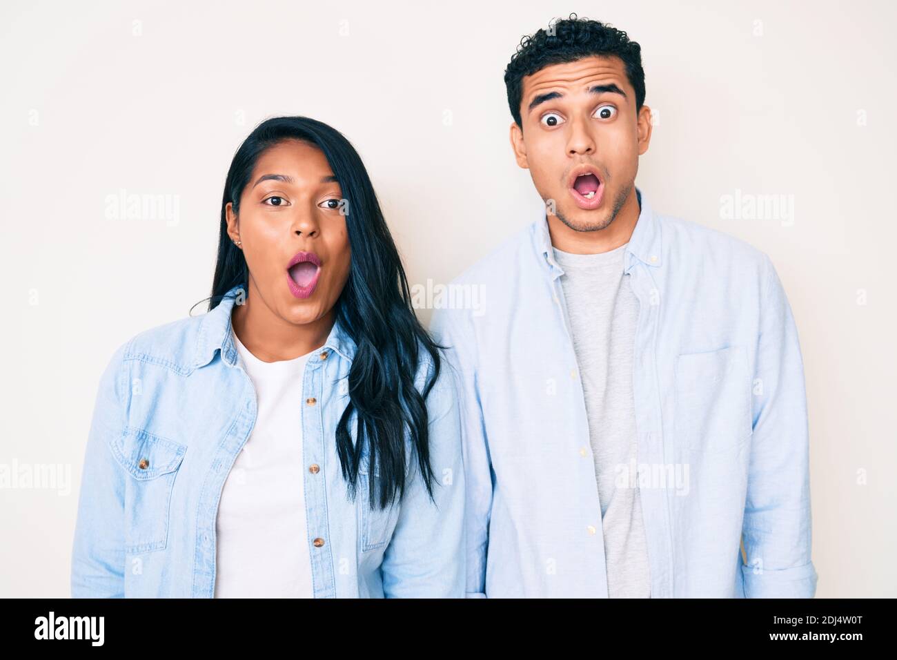 Beautiful latin young couple wearing casual clothes afraid and shocked ...