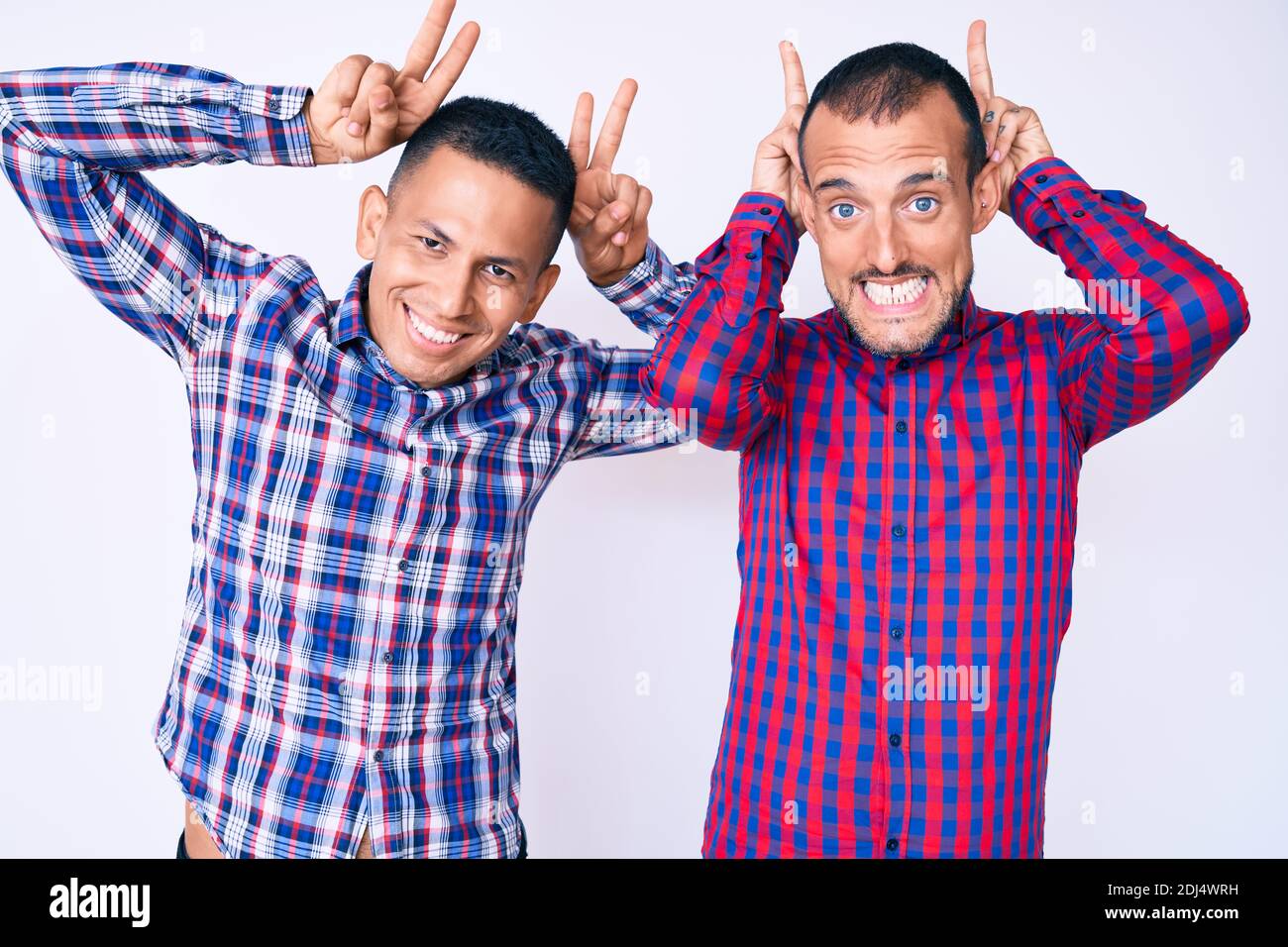 Young gay couple of two men wearing casual clothes posing funny and ...