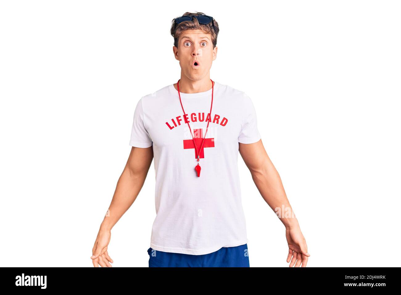 Young handsome man wearing lifeguard t shirt and whistle scared and ...