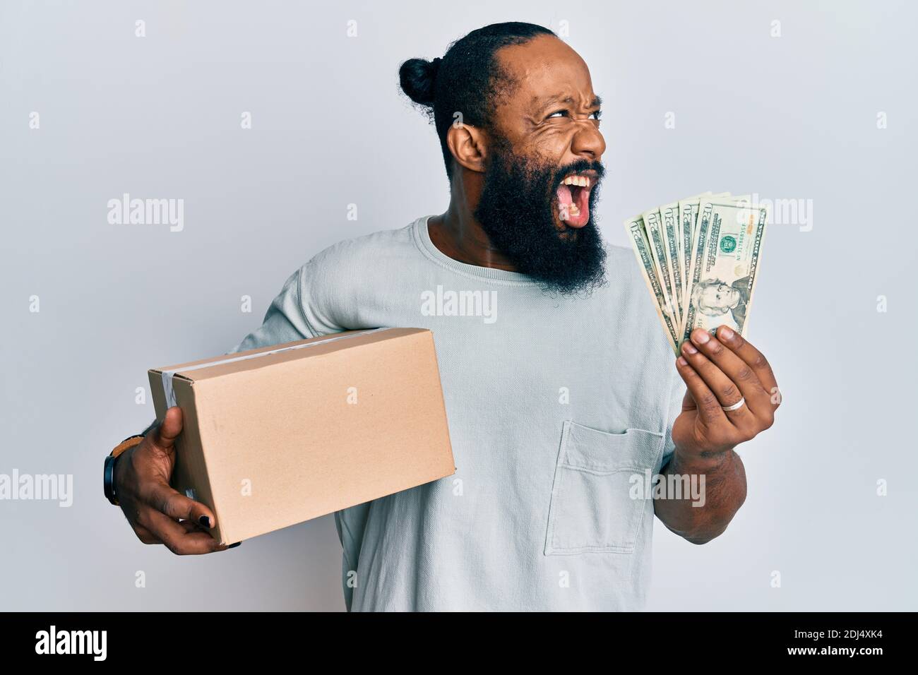 Young african american man holding delivery box and usa dollars ...