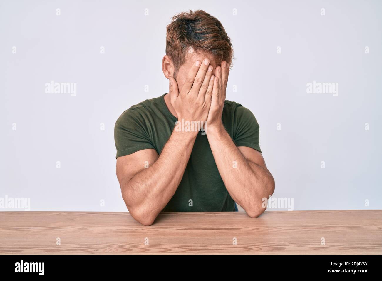 Young caucasian man wearing casual clothes sitting on the table with ...