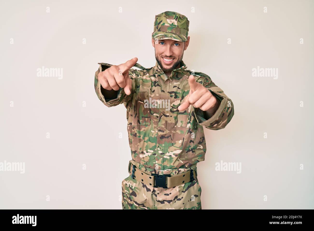 Young caucasian man wearing camouflage army uniform pointing to you and ...