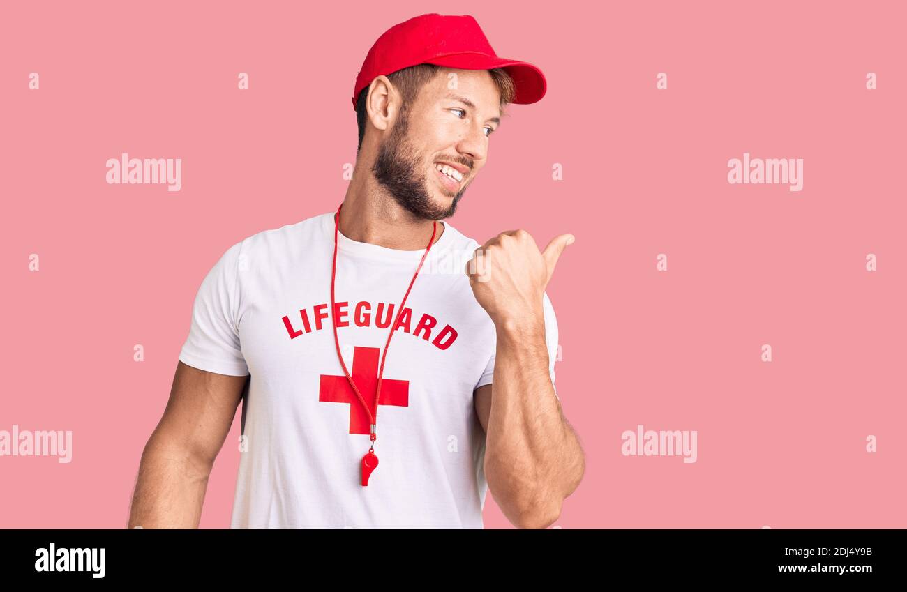 Young caucasian man wearing lifeguard t shirt holding whistle smiling ...