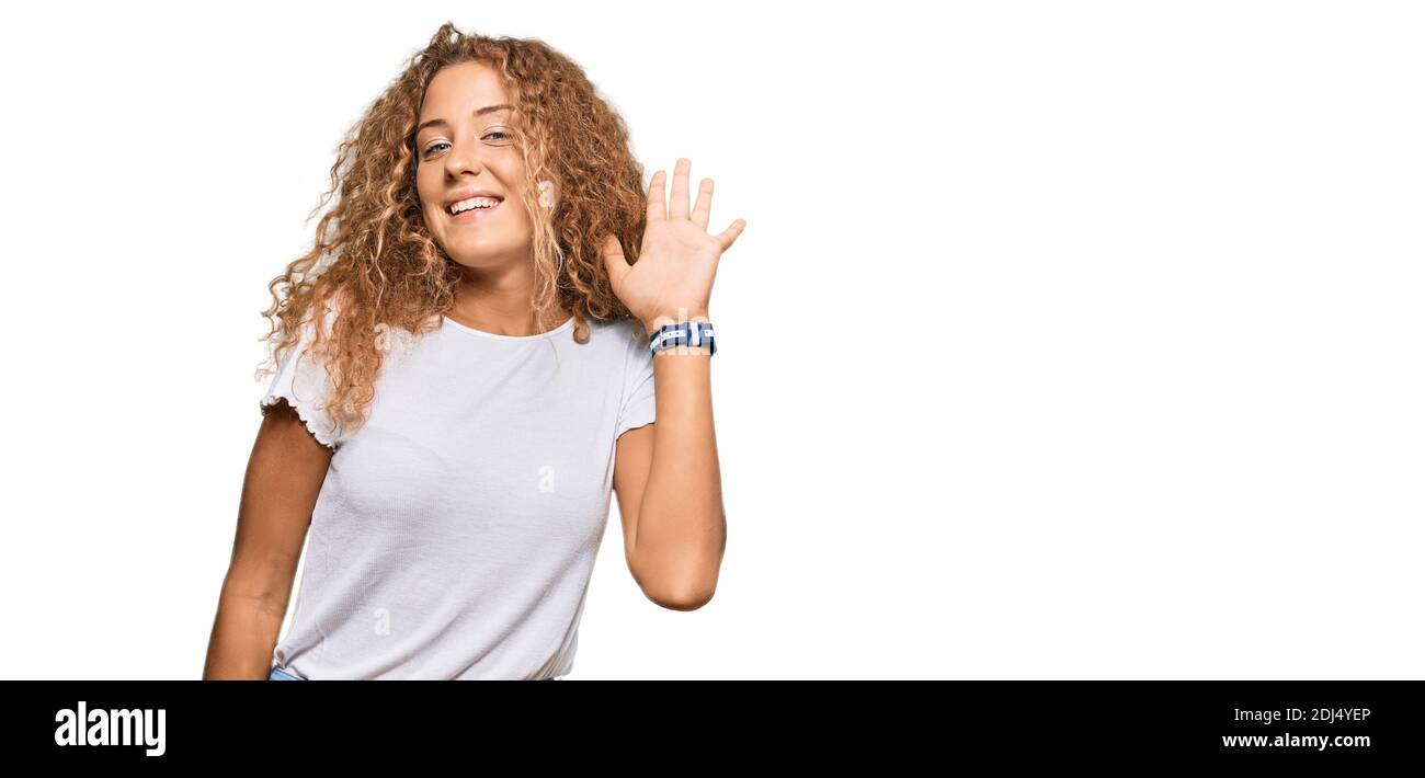 Beautiful caucasian teenager girl wearing casual white tshirt waiving ...