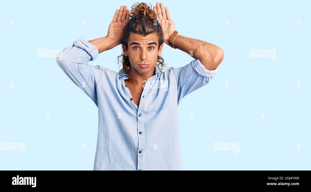Young hispanic man wearing summer style doing bunny ears gesture with ...