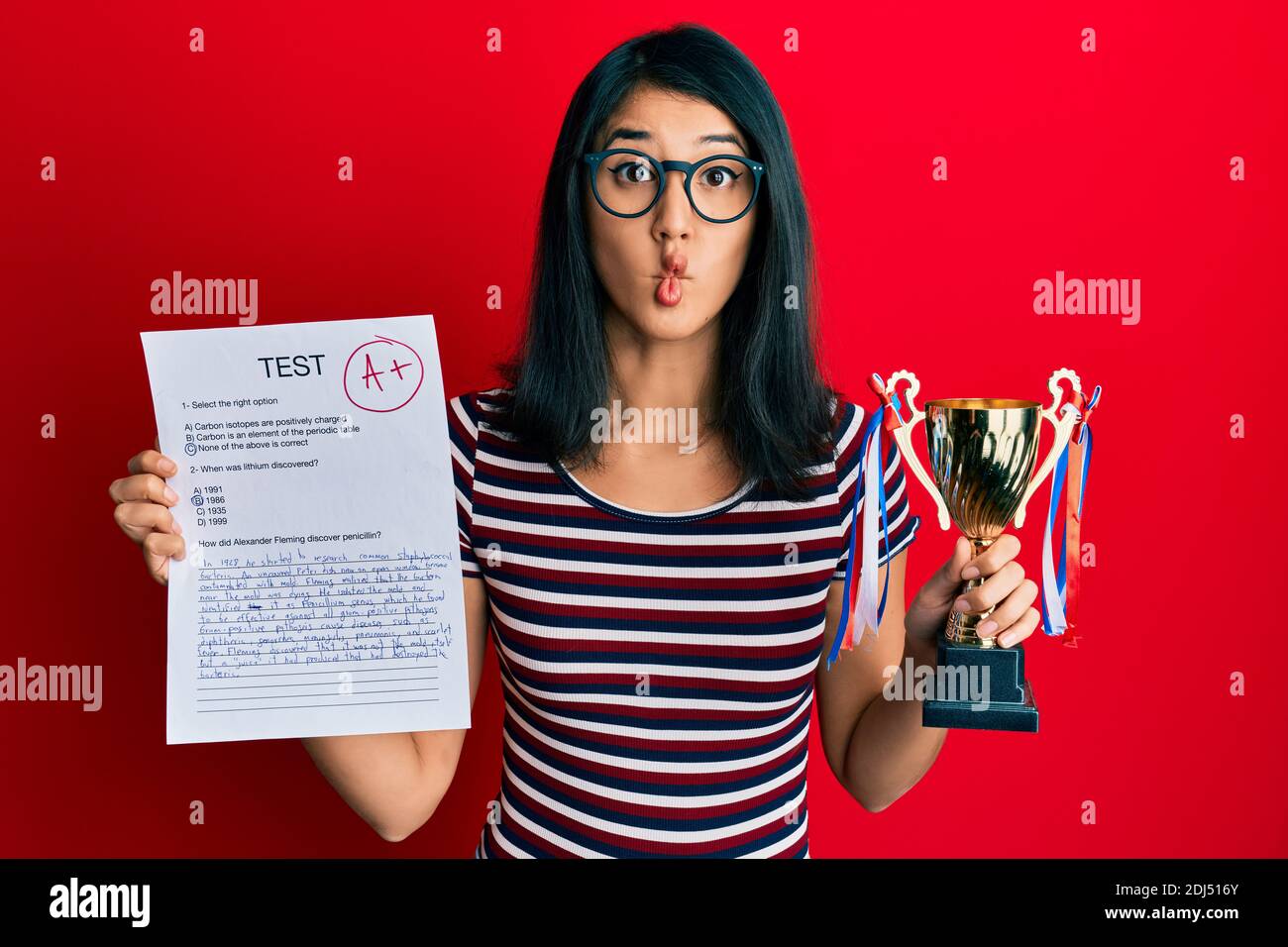 Beautiful asian young woman showing a passed exam holding trophy making ...