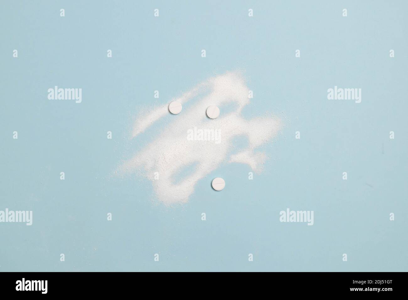 Various dangerous drugs in the form of powder and tablets on a blue ...