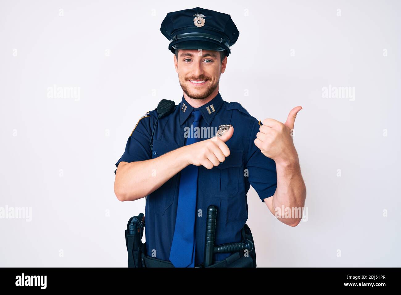 Young caucasian man wearing police uniform pointing to the back behind ...