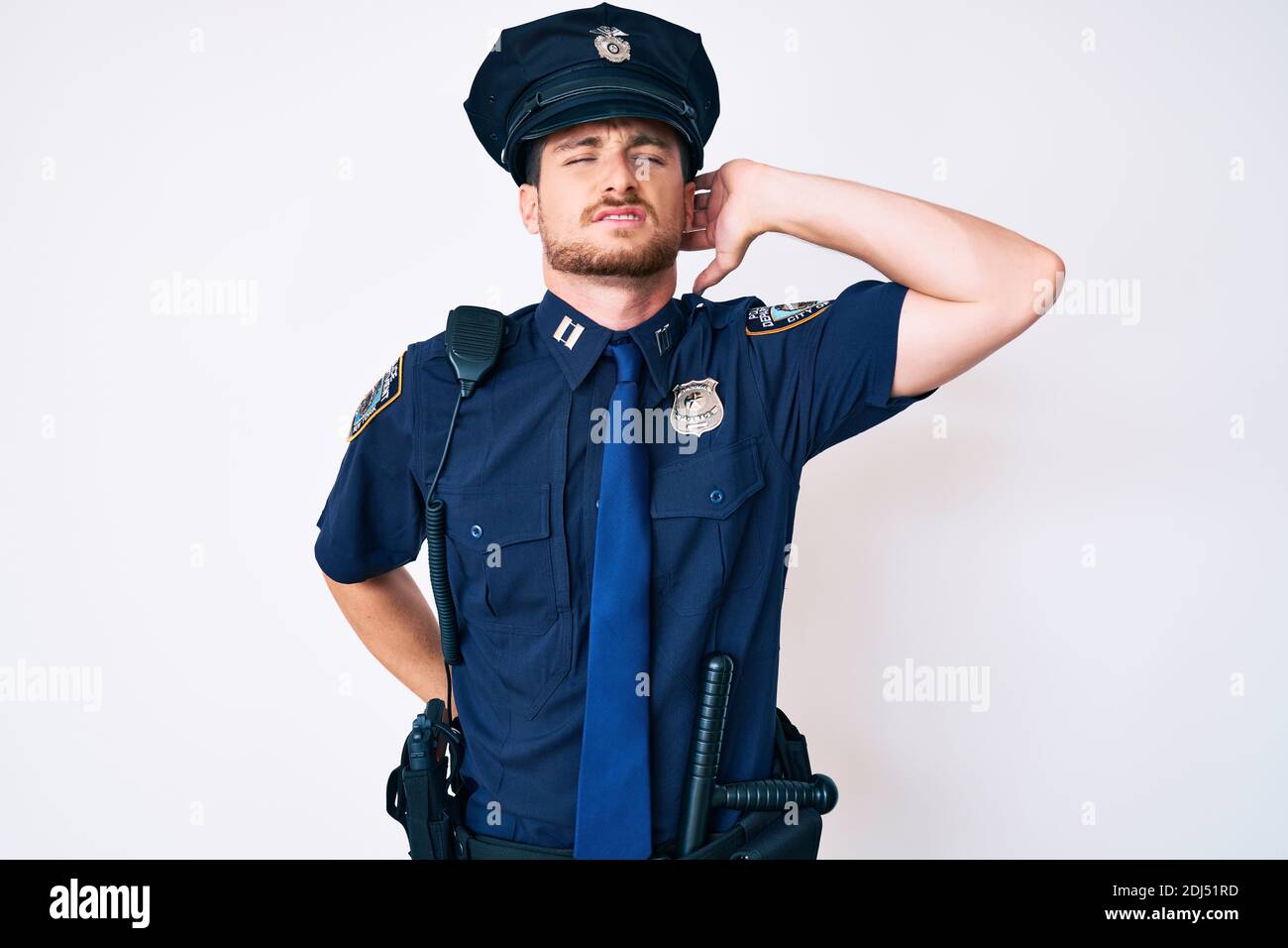 Young caucasian man wearing police uniform suffering of neck ache ...