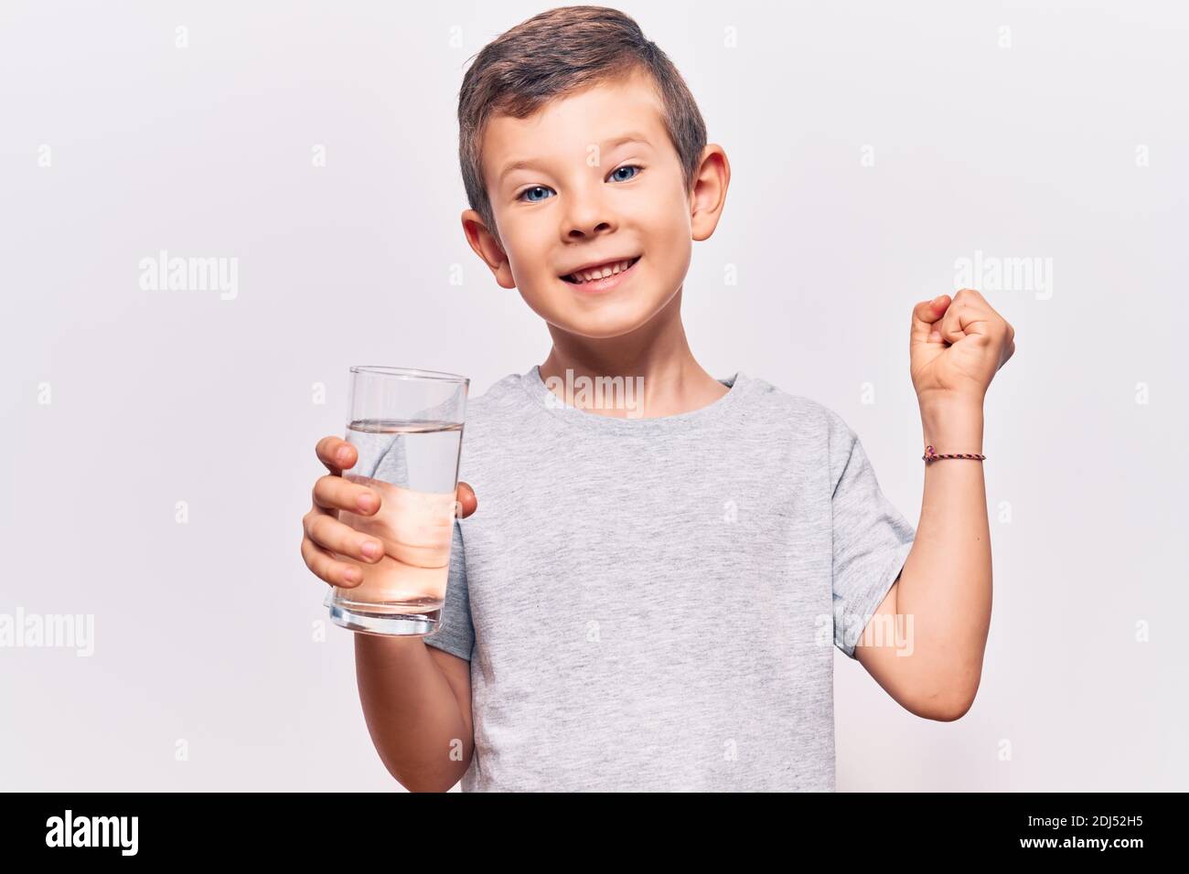 Cute blond kid drinking glass of water screaming proud, celebrating ...