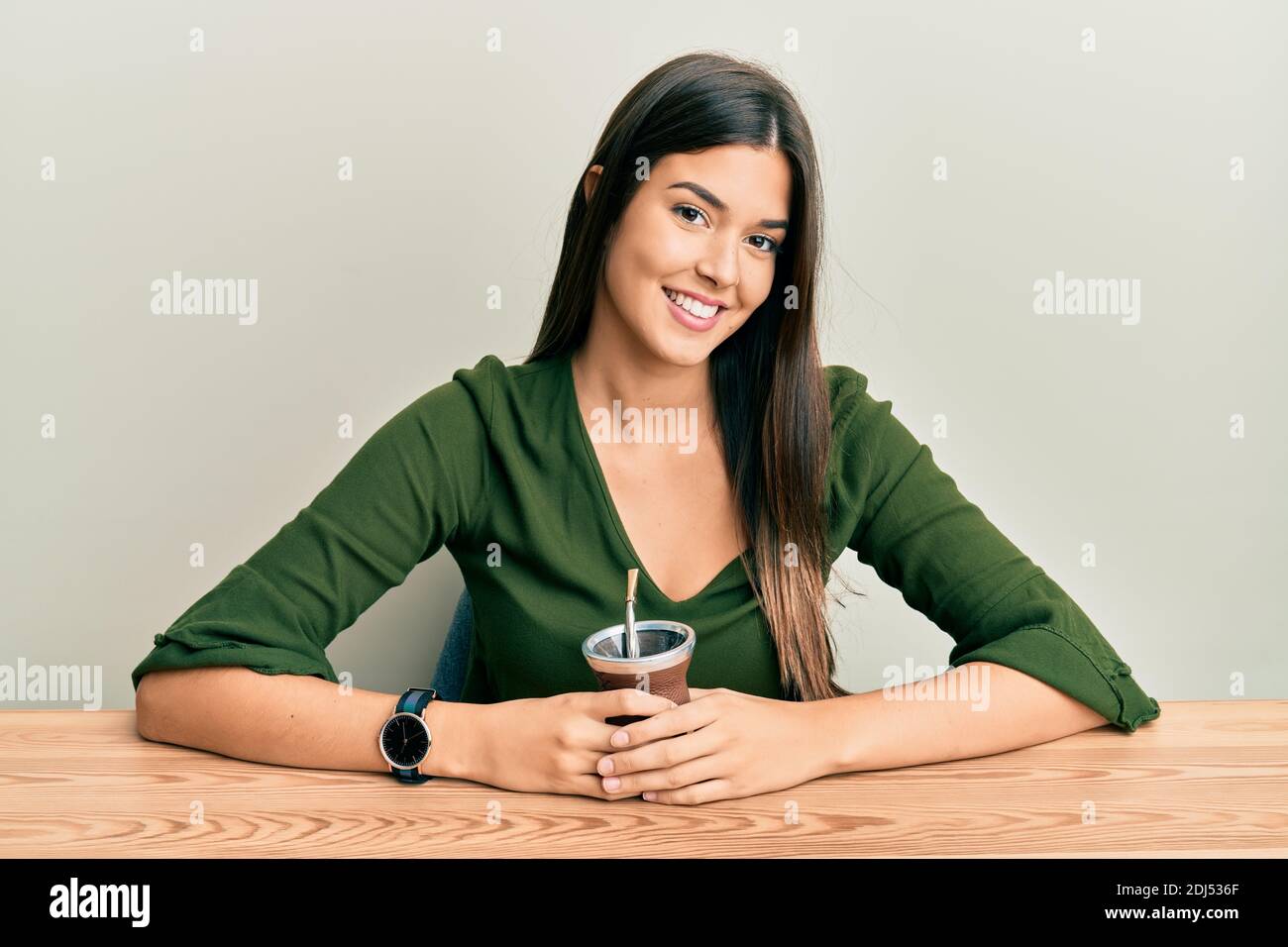 Young brunette woman drinking mate infusion looking positive and happy ...