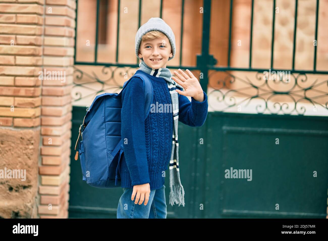 Adorable blond student kid saying goodbye with hand getting in the ...