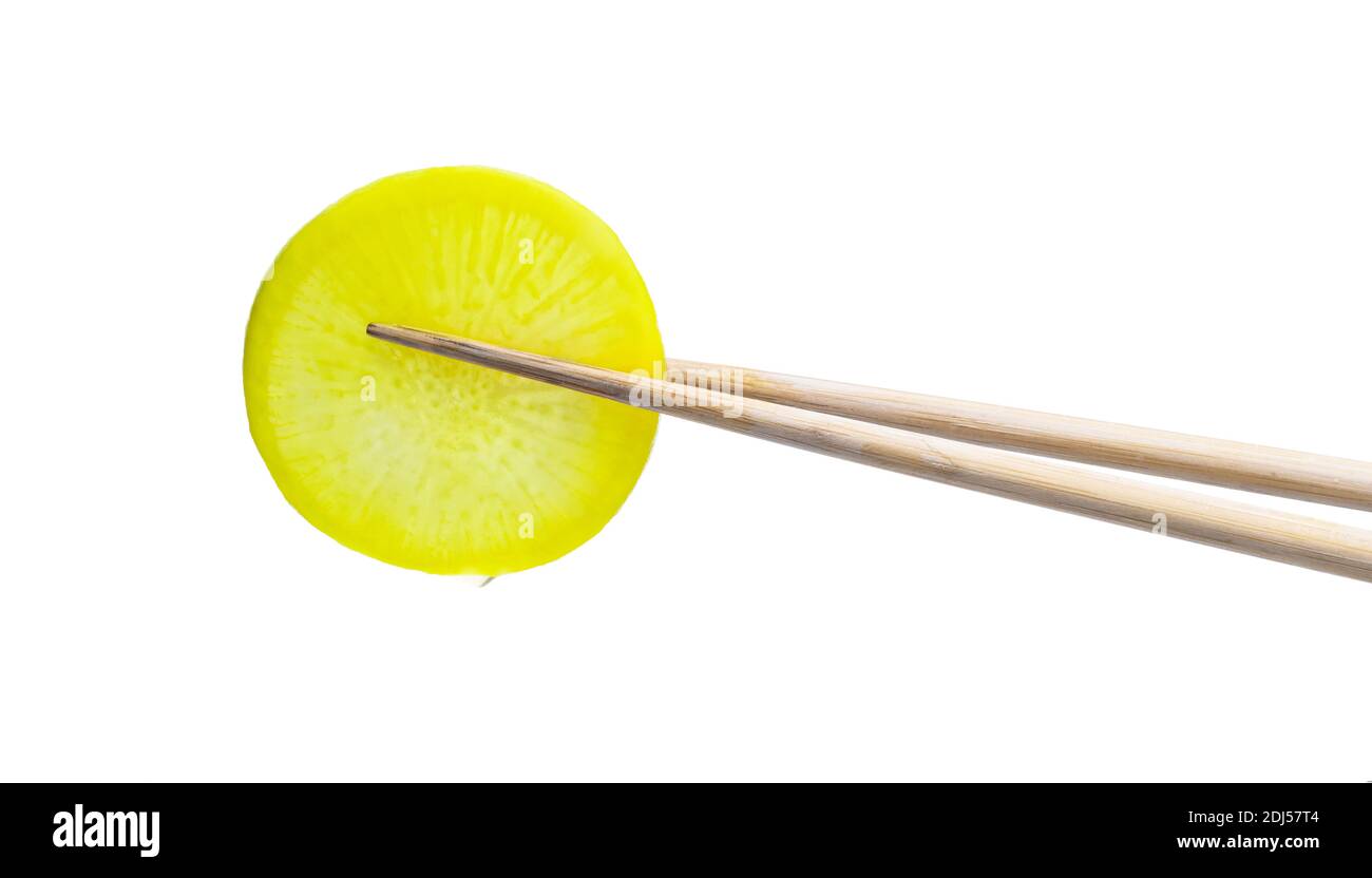 Marinated daikon slice picked up with chopsticks isolated on white ...
