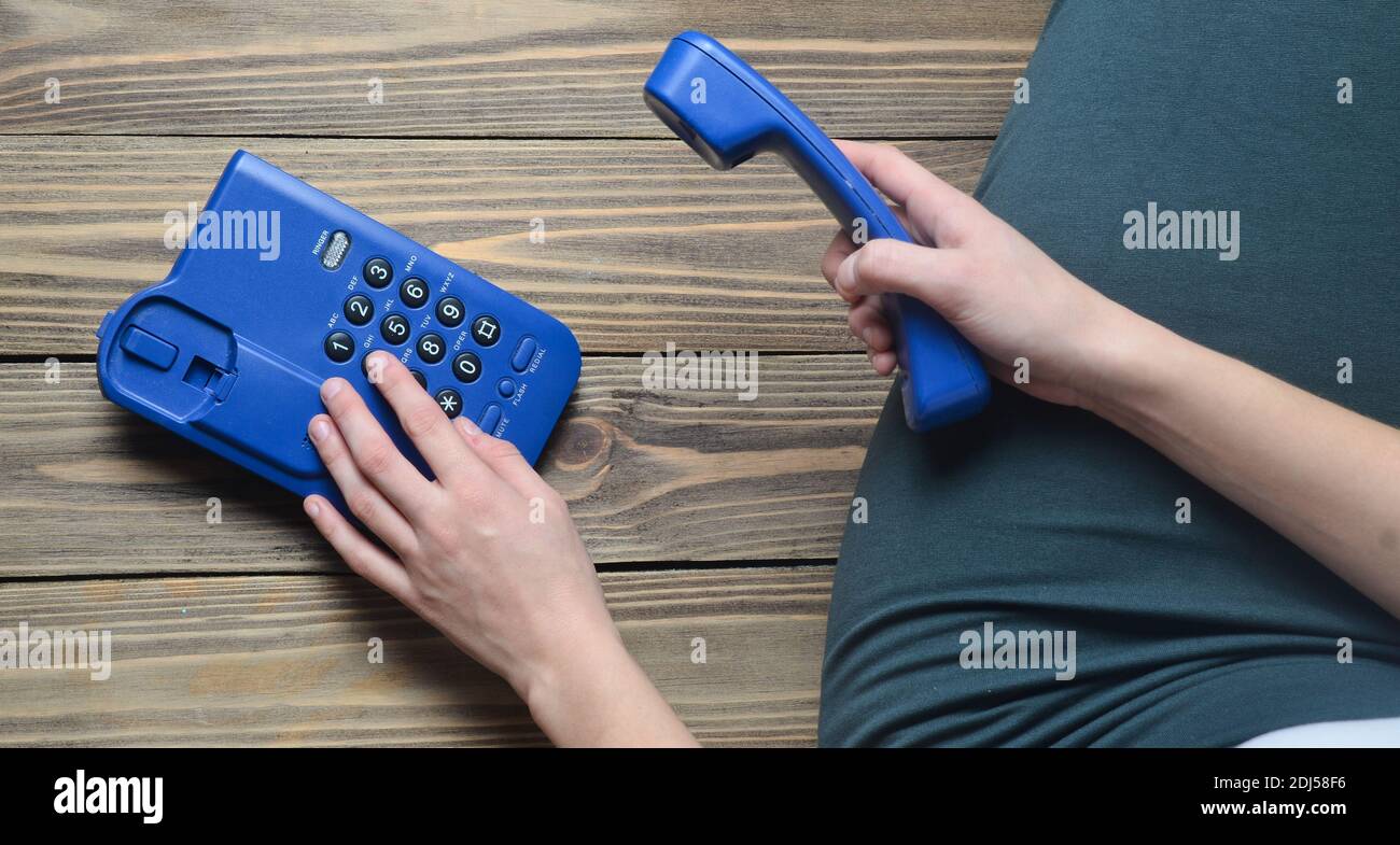 The secretary is sitting on the wooden floor and calling the office ...