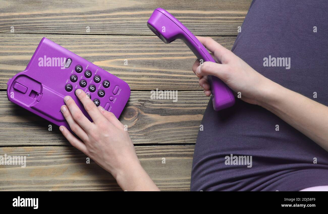 The secretary is sitting on the wooden floor and calling the office ...