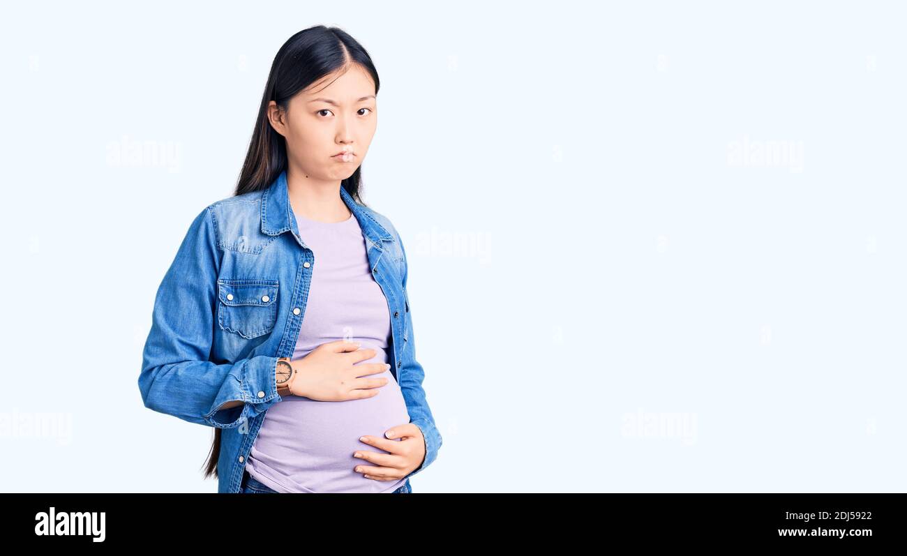 Young beautiful chinese woman pregnant expecting baby depressed and ...