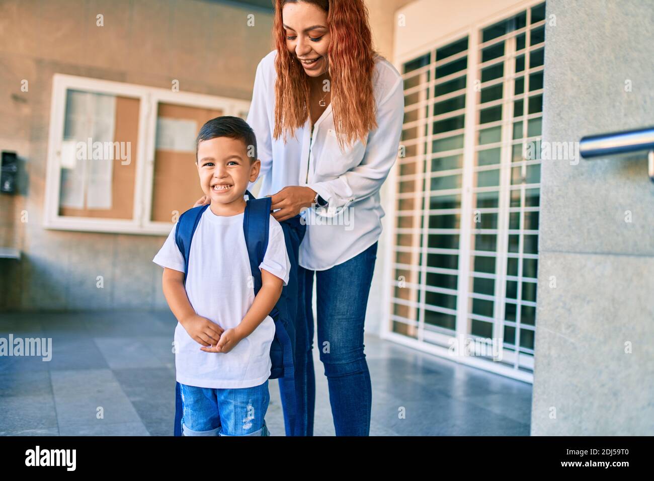 Adorable latin student boy and mom at school. Mother preparing kid ...