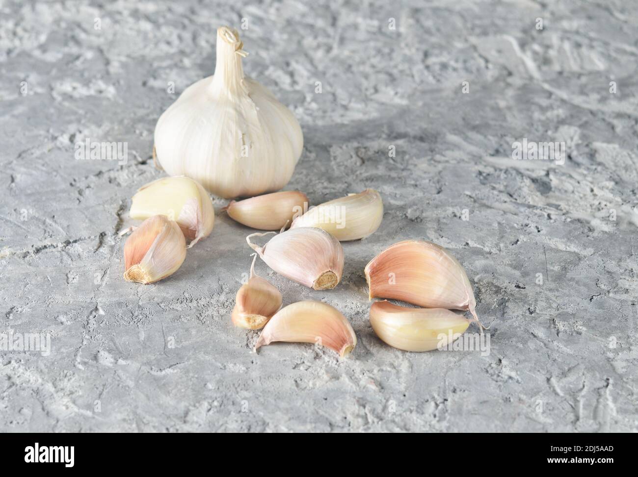 Garlic cloves on a gray concrete surface Stock Photo - Alamy
