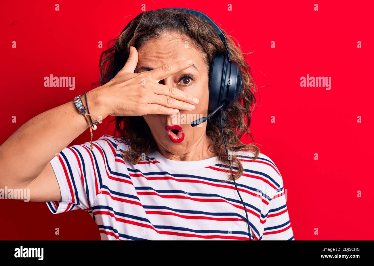 Middle age brunette gamer woman playing video game using headphones and ...