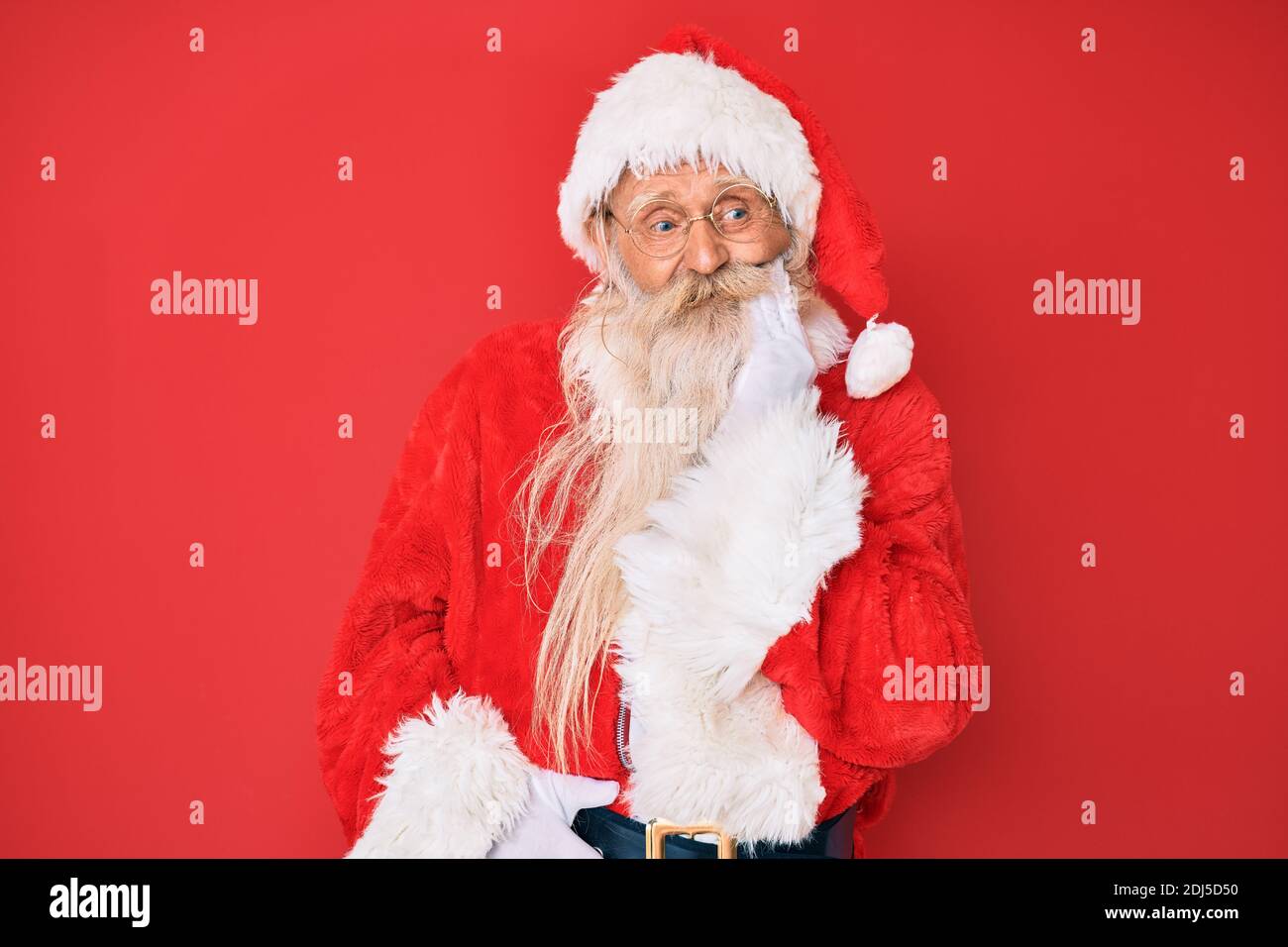 Old senior man with grey hair and long beard wearing traditional santa ...