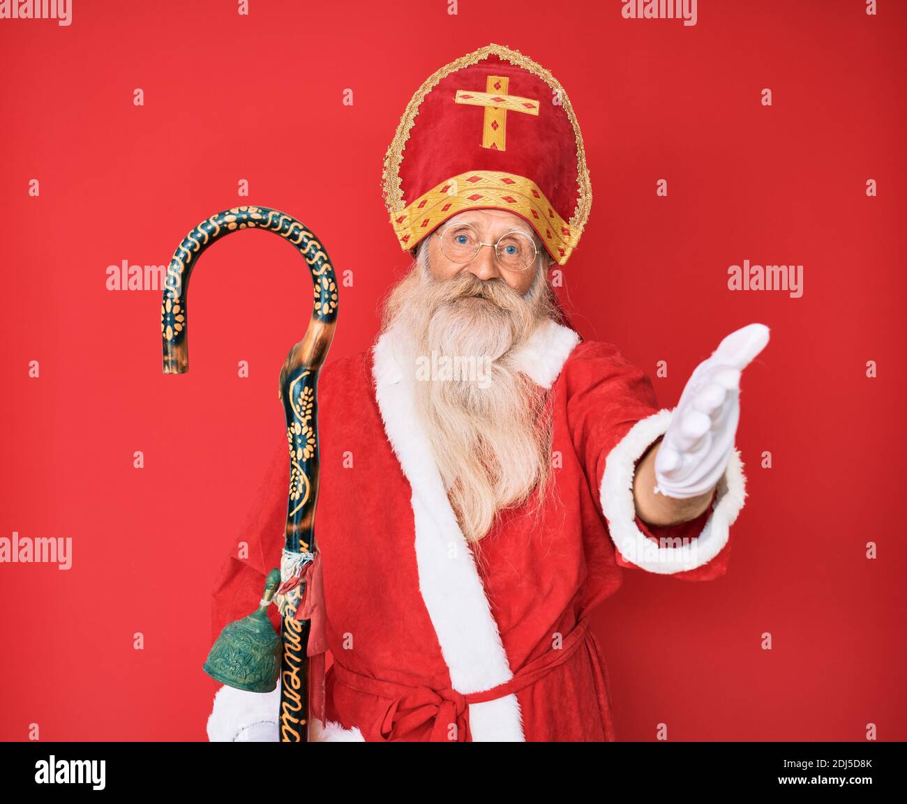 Old senior man with grey hair and long beard wearing traditional saint ...
