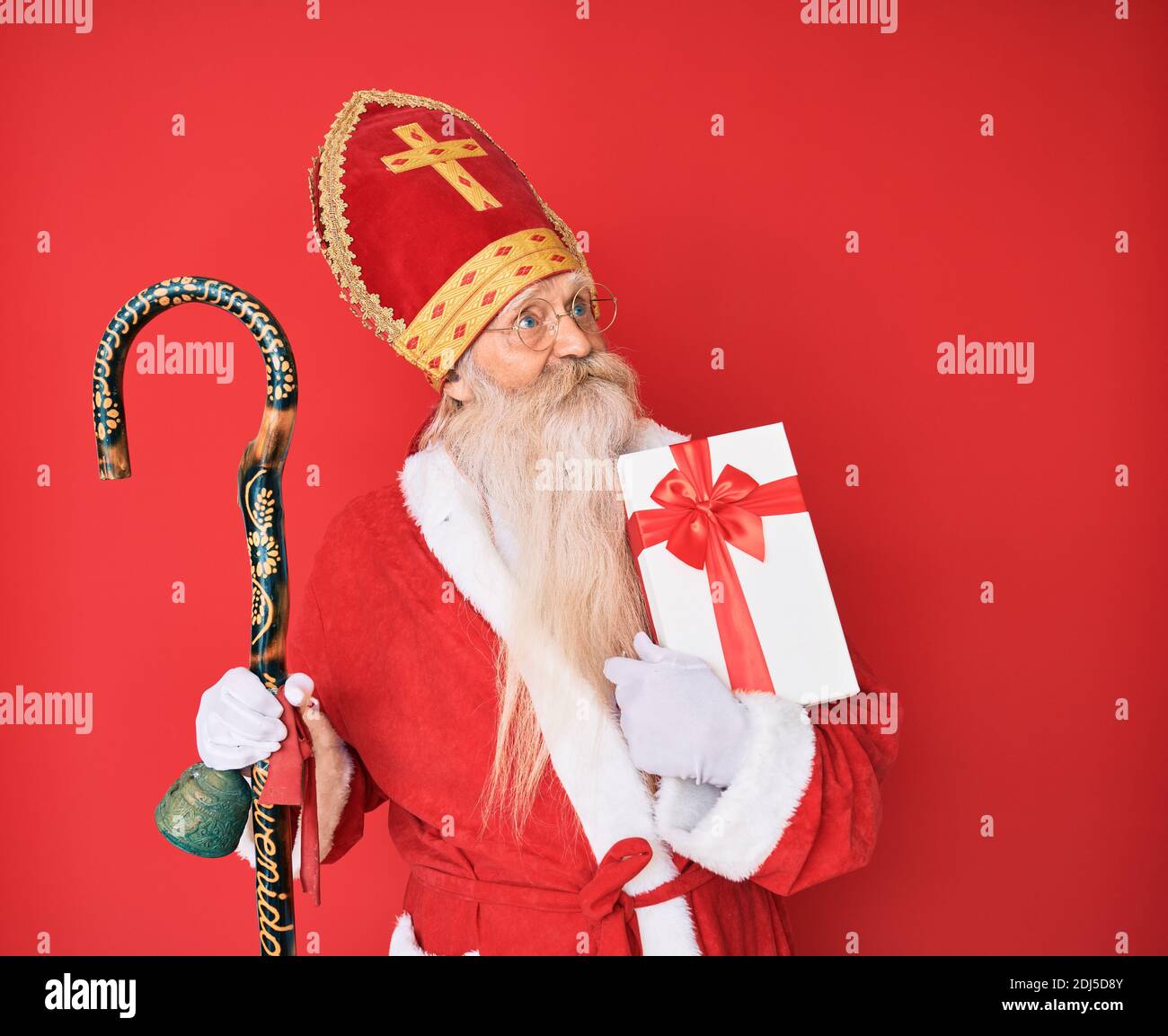 Old senior man with grey hair and long beard wearing saint nicholas ...