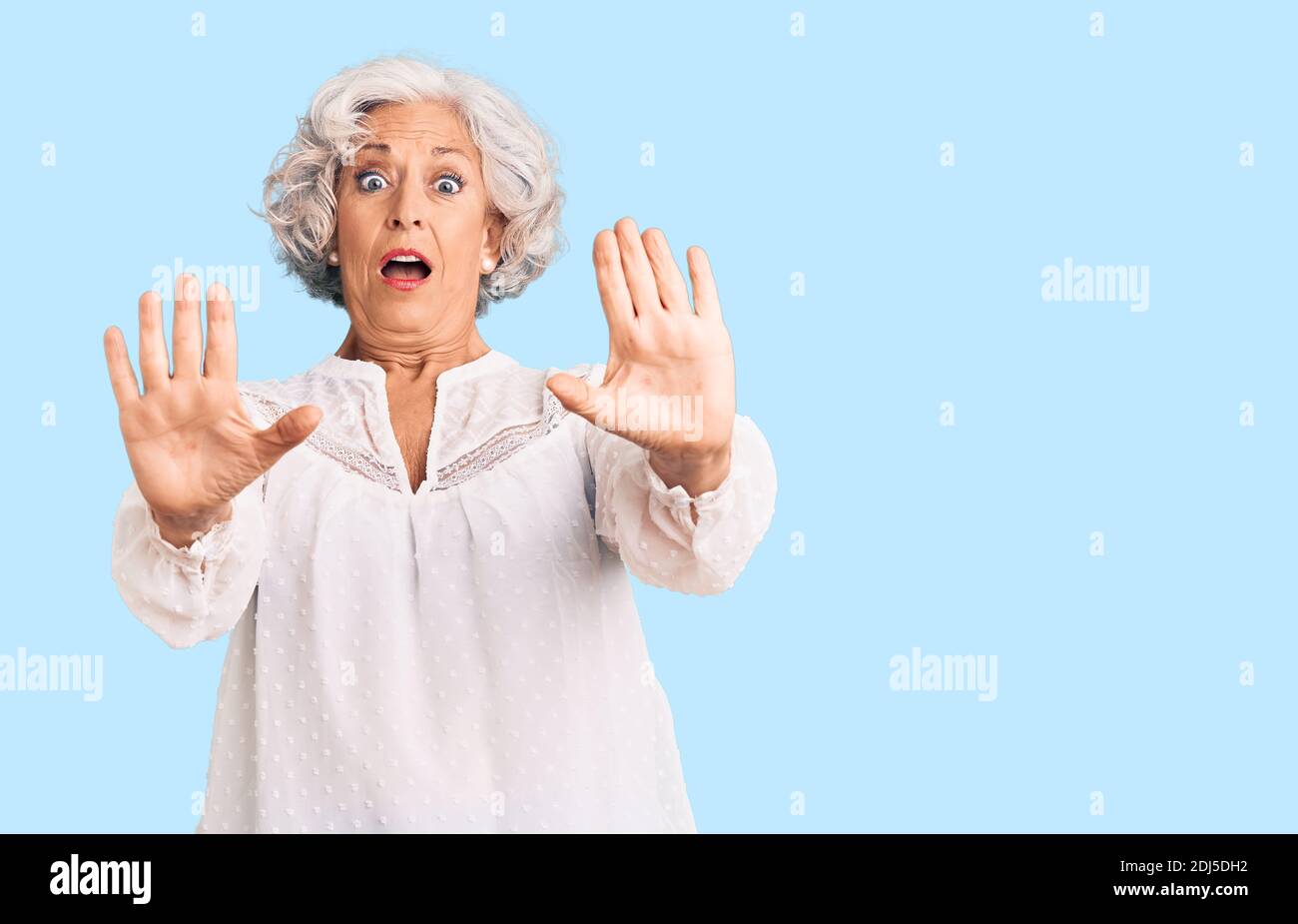 Senior grey-haired woman wearing casual clothes afraid and terrified ...