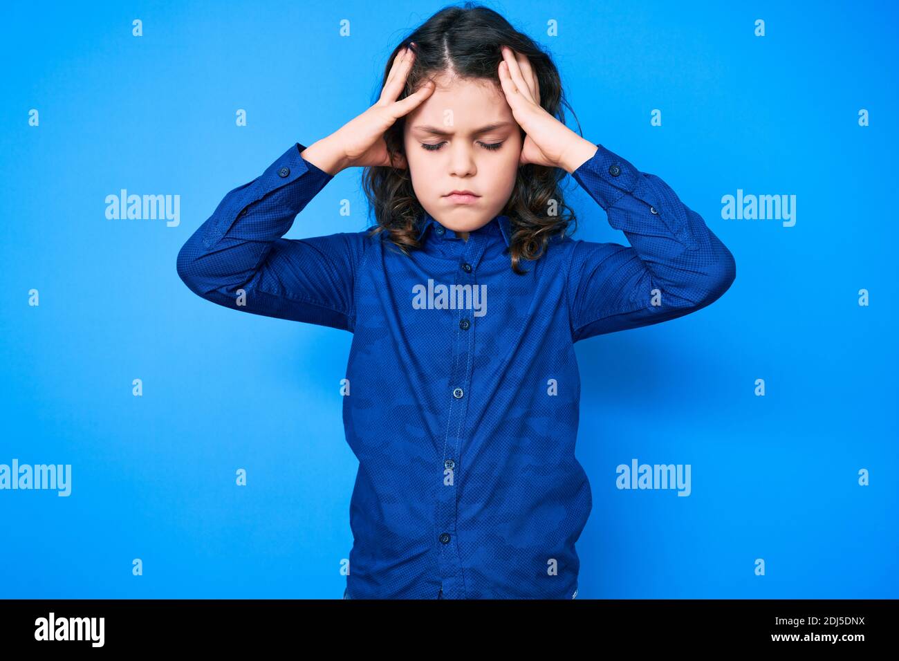 Cute hispanic child with long hair wearing casual clothes suffering ...