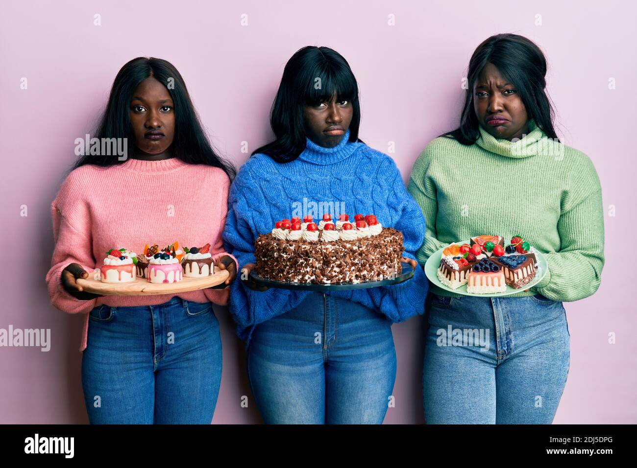 Young african american friends celebrating birthday holding cakes ...