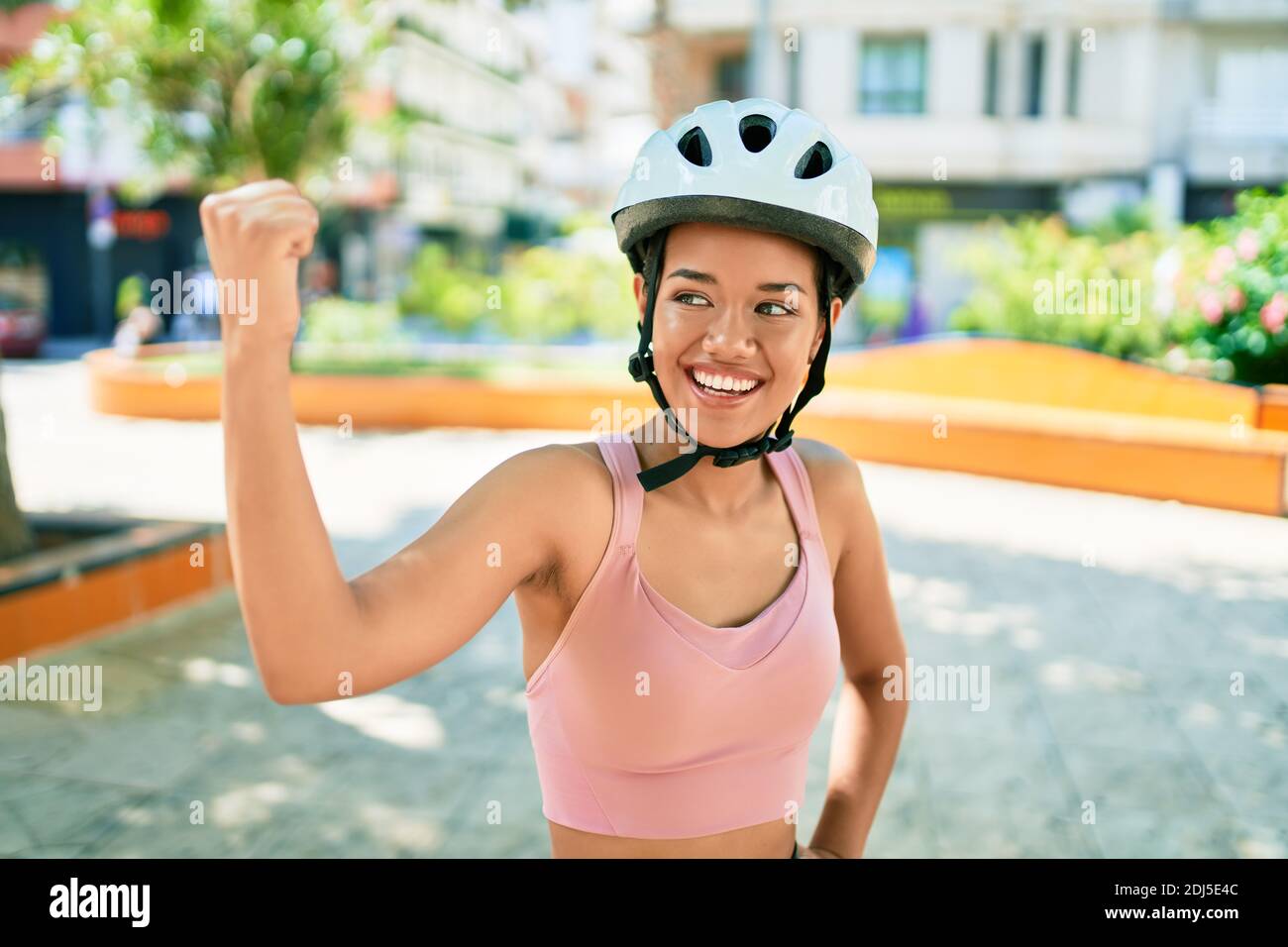 Young beautiful hispanic cyclist woman smiling happy wearing bike ...