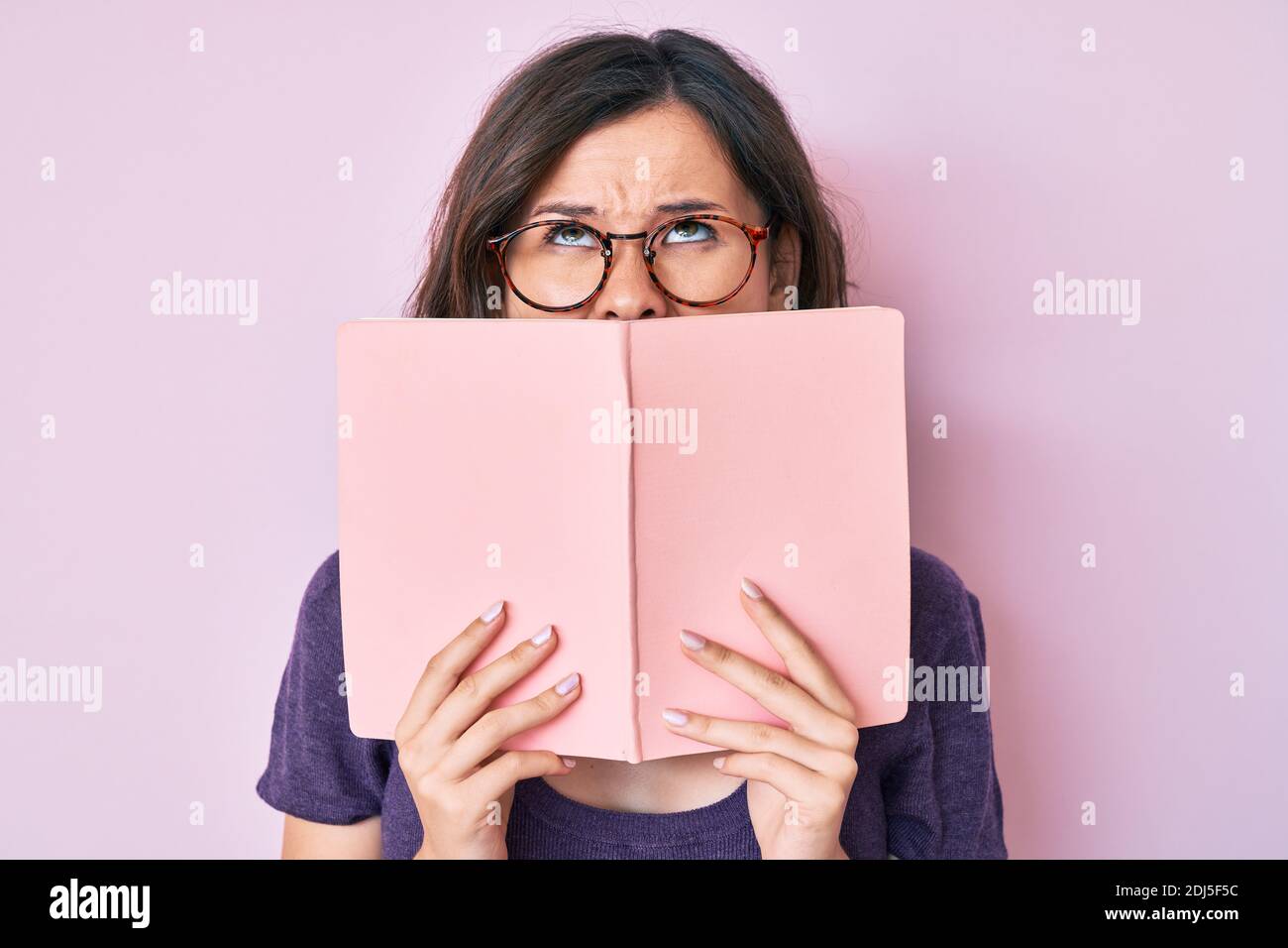 Young beautiful woman wearing glasses reading book angry and mad ...