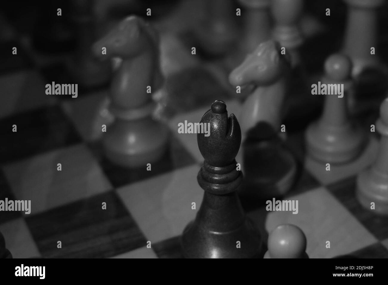 A greyscale shot of chess pieces on a wooden chessboard Stock Photo - Alamy