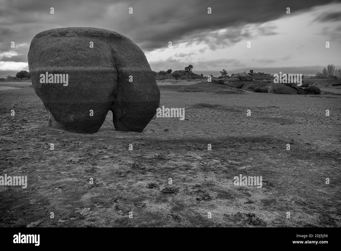 A grayscale shot of a massive rock shaped like a butt at the natural ...