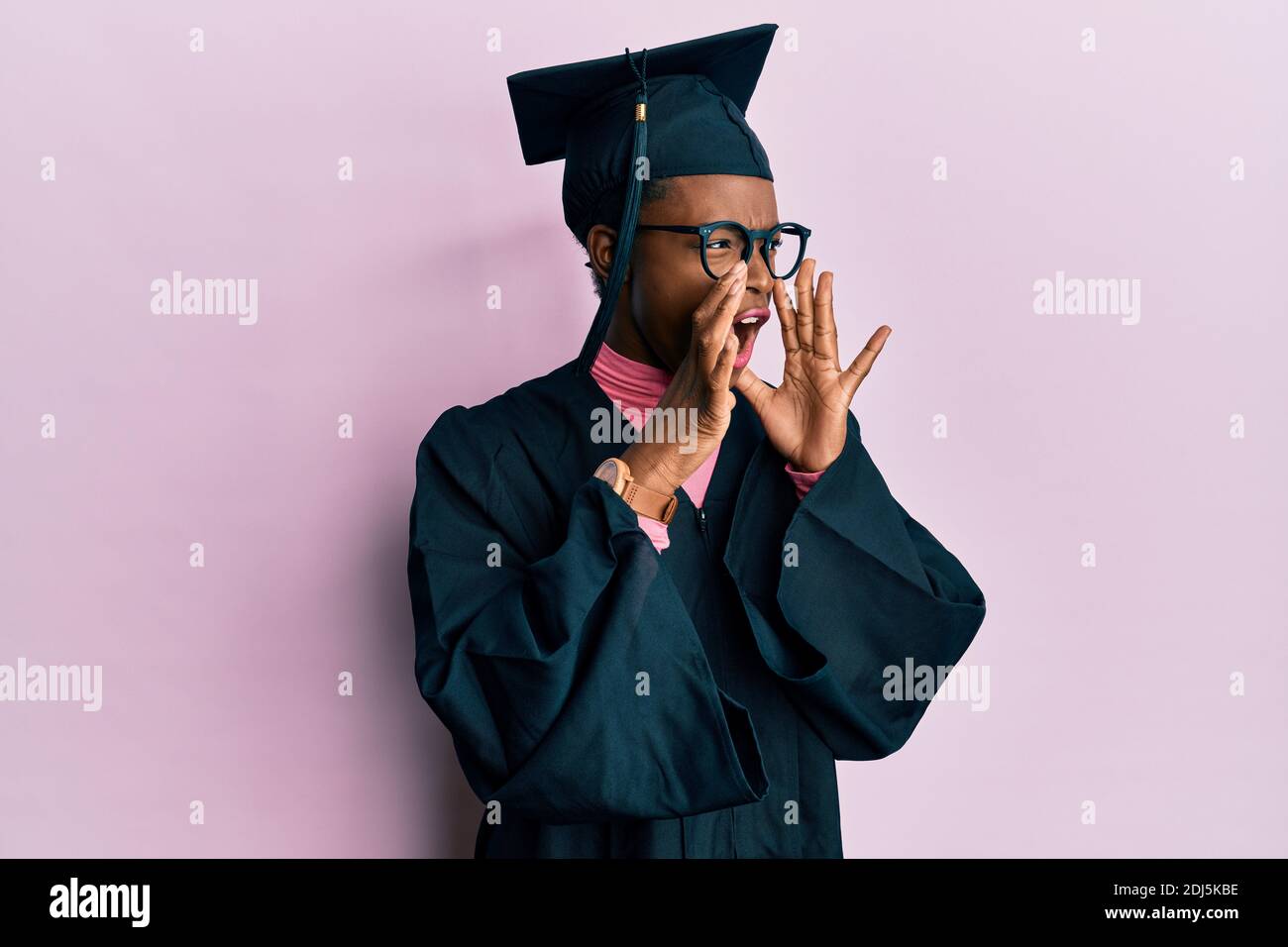 Young african american girl wearing graduation cap and ceremony robe ...