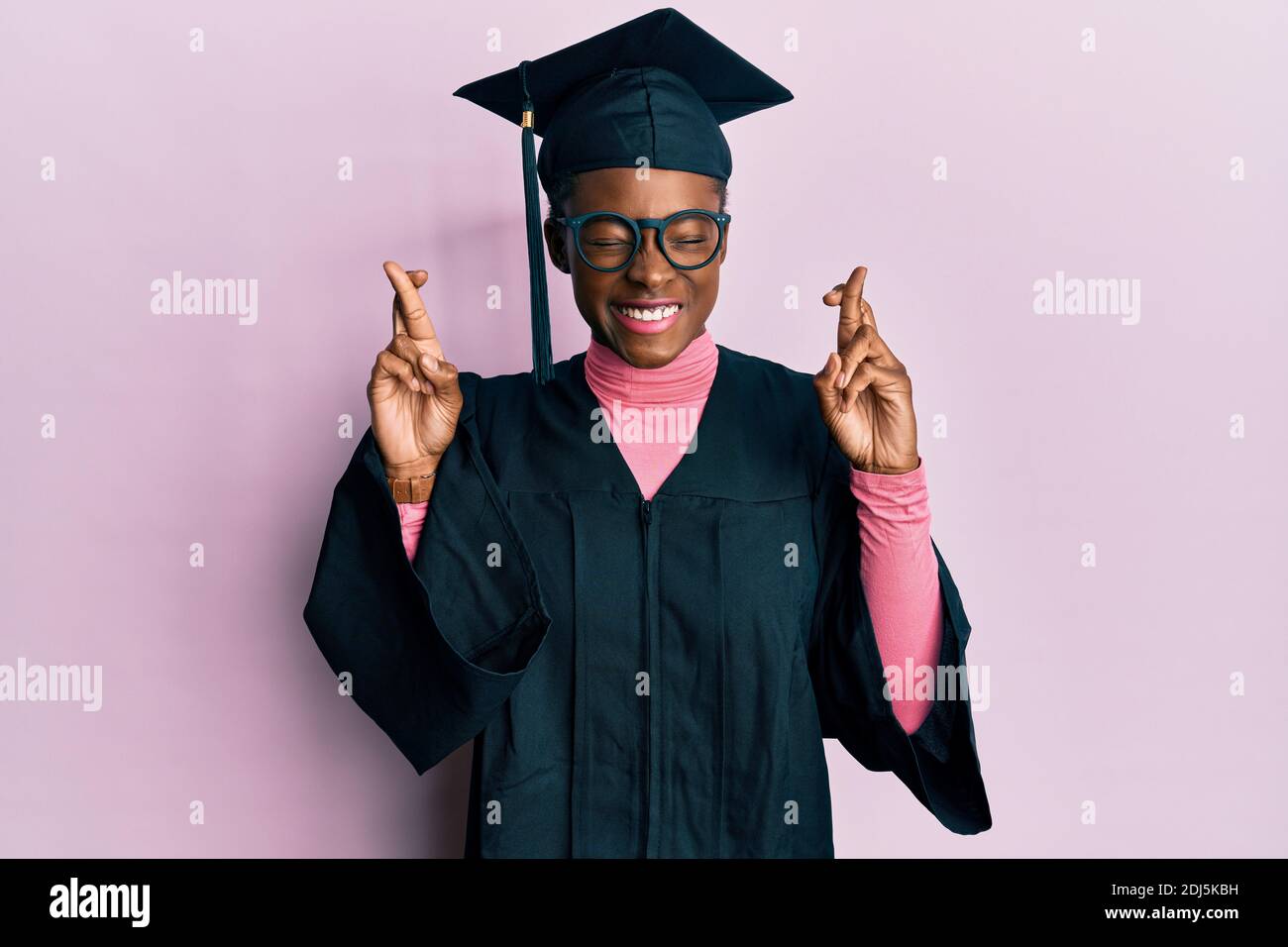 Young african american girl wearing graduation cap and ceremony robe ...