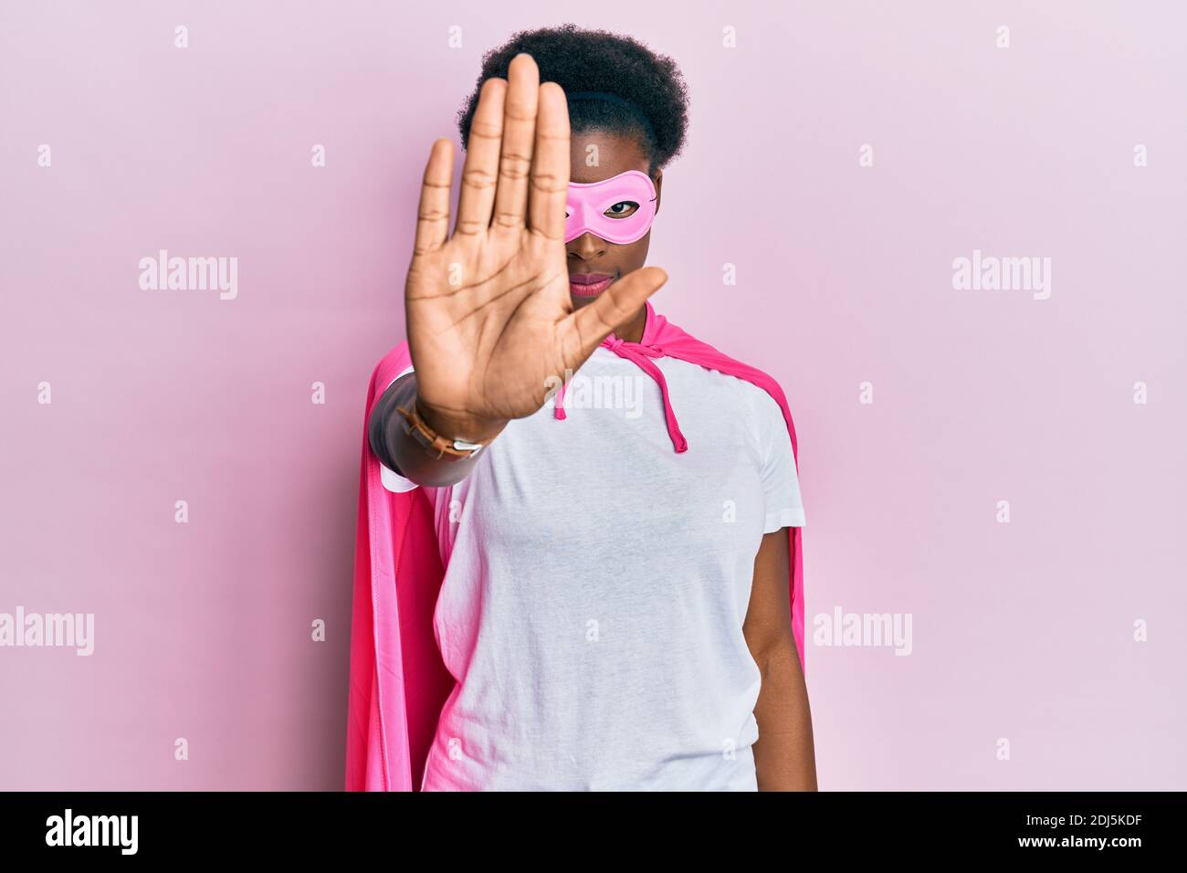 Young african american girl wearing superhero mask and cape costume ...