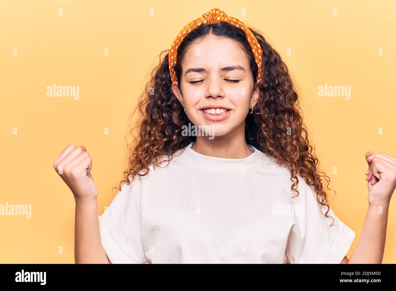 Beautiful kid girl with curly hair wearing casual clothes very happy ...