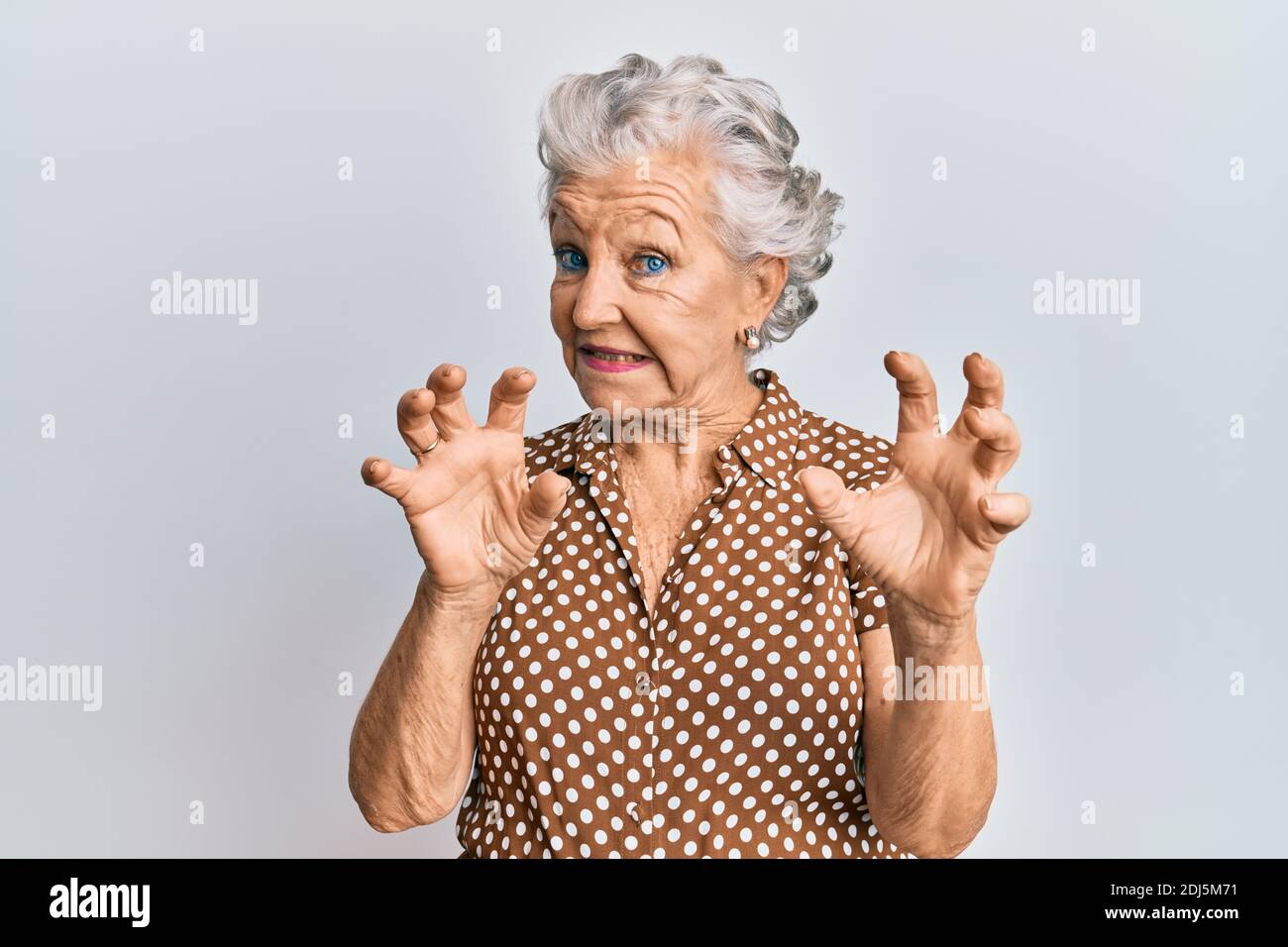 Senior grey-haired woman wearing casual clothes afraid and terrified ...