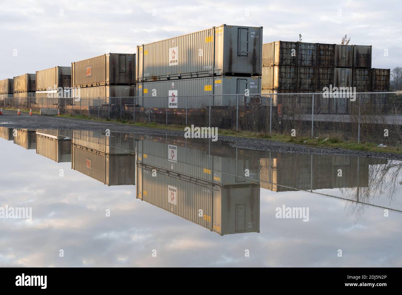 Line of stacked intermodal steel containers reflected in water Stock ...