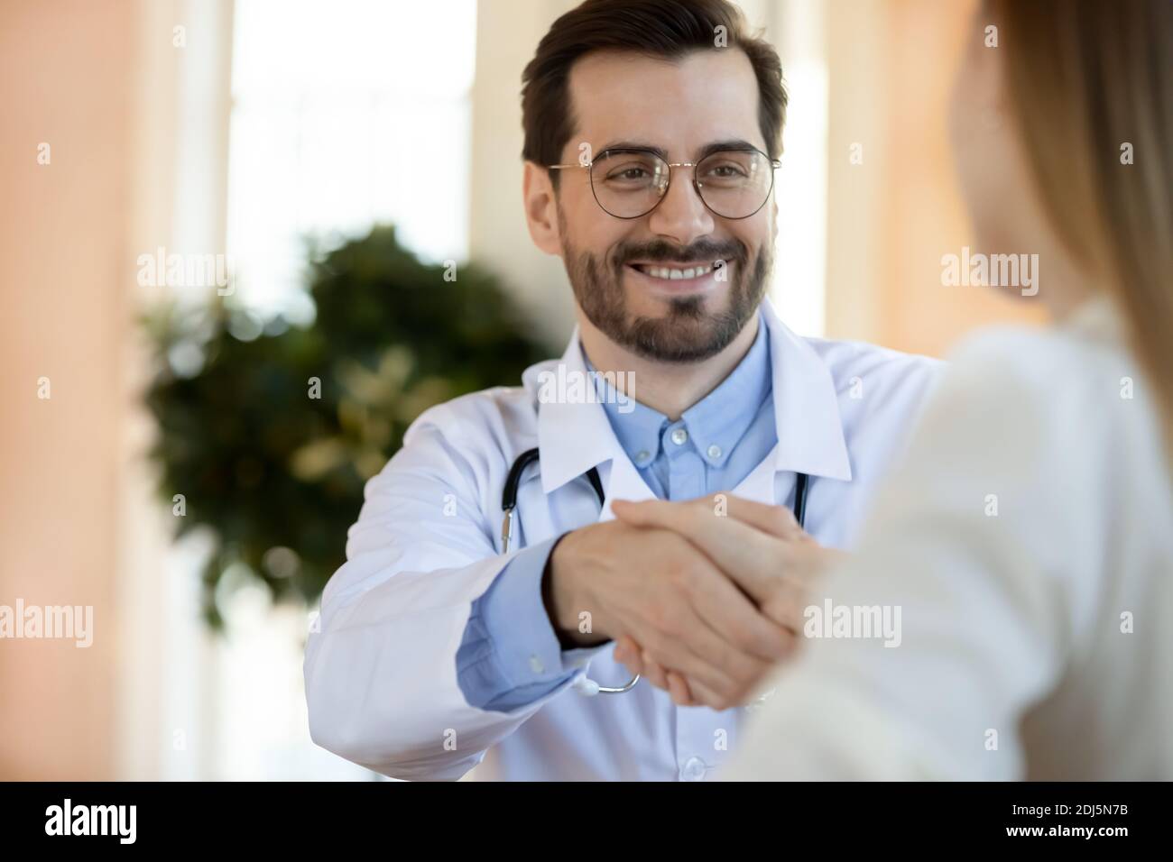 Smiling male doctor handshake close deal with patient Stock Photo - Alamy