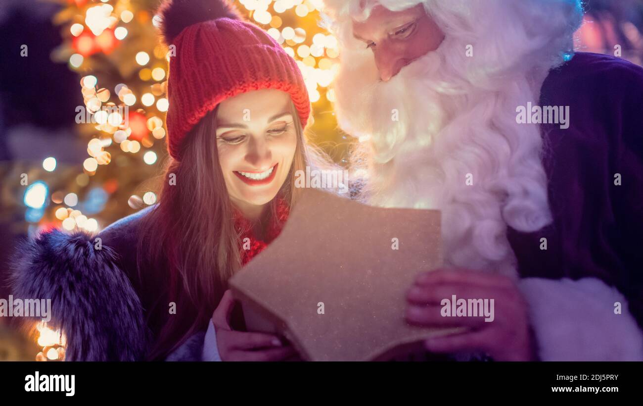 Woman receiving a present from Santa Claus Stock Photo - Alamy