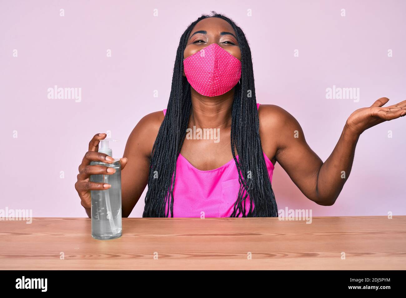 African american woman with braids wearing medical mask holding hand ...