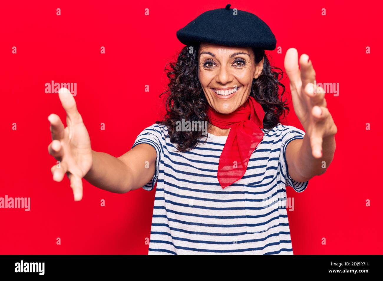 Middle age beautiful woman wearing french beret looking at the camera ...
