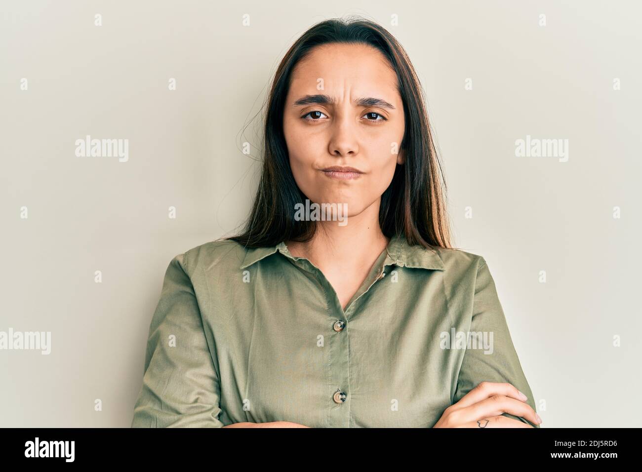 Young hispanic woman wearing casual clothes skeptic and nervous ...